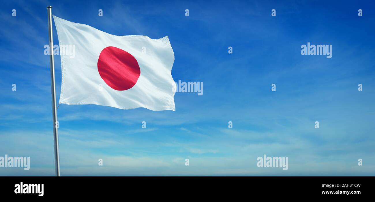 The National flag of Japan blowing in the wind in front of a clear blue ...