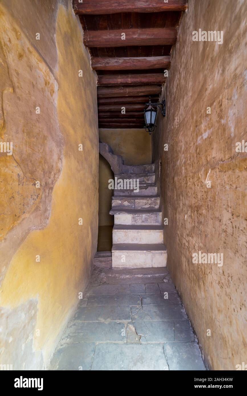 Day shot of old narrow passage and stone staircase and wooden ceiling ...