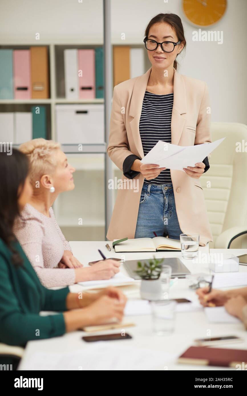Beautiful Asian woman standing at table making presentation at business ...