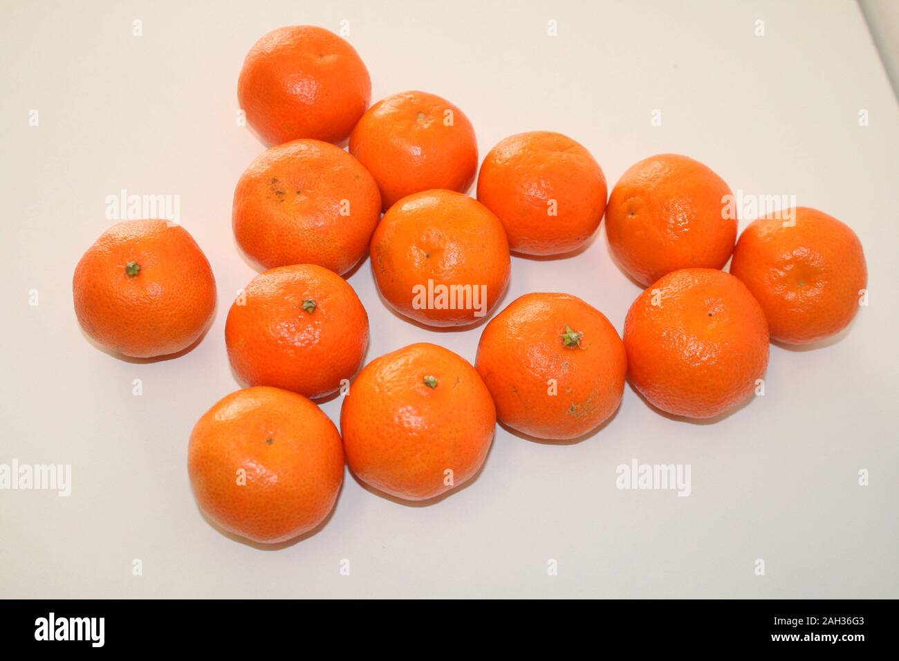Tangerines lined in the shape of a Christmas tree on a white background ...