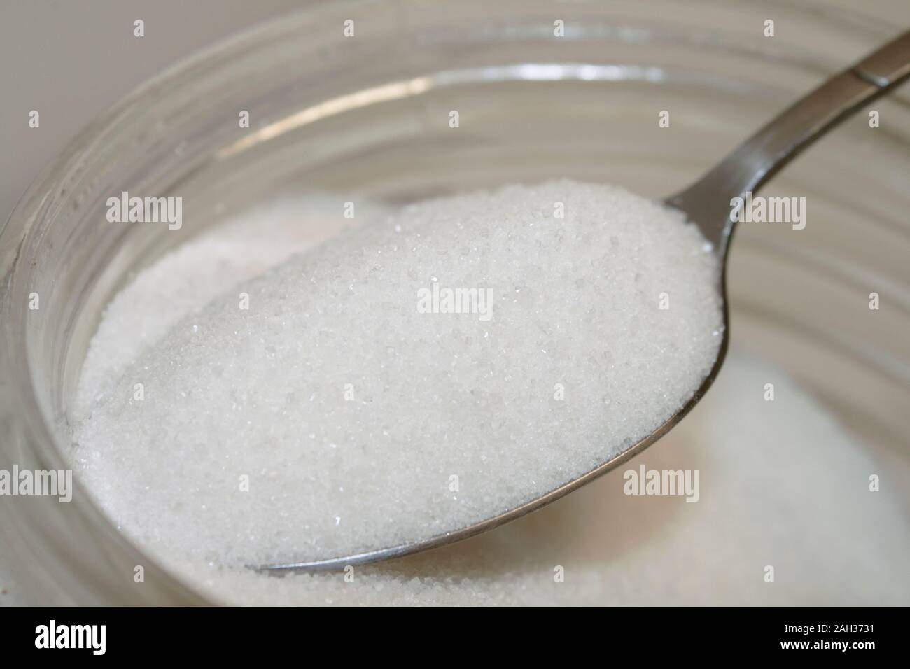 Sugar in a spoon in a bowl on a white background Stock Photo - Alamy