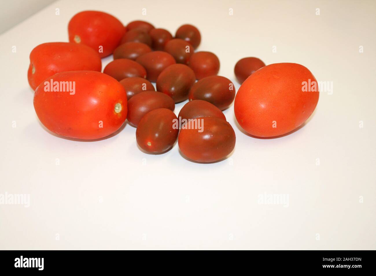 Set of tomatoes on a white table Stock Photo - Alamy