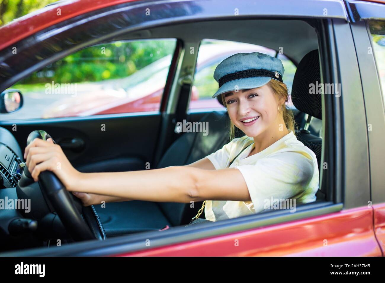 Happy woman driver behind the wheel red car Stock Photo - Alamy