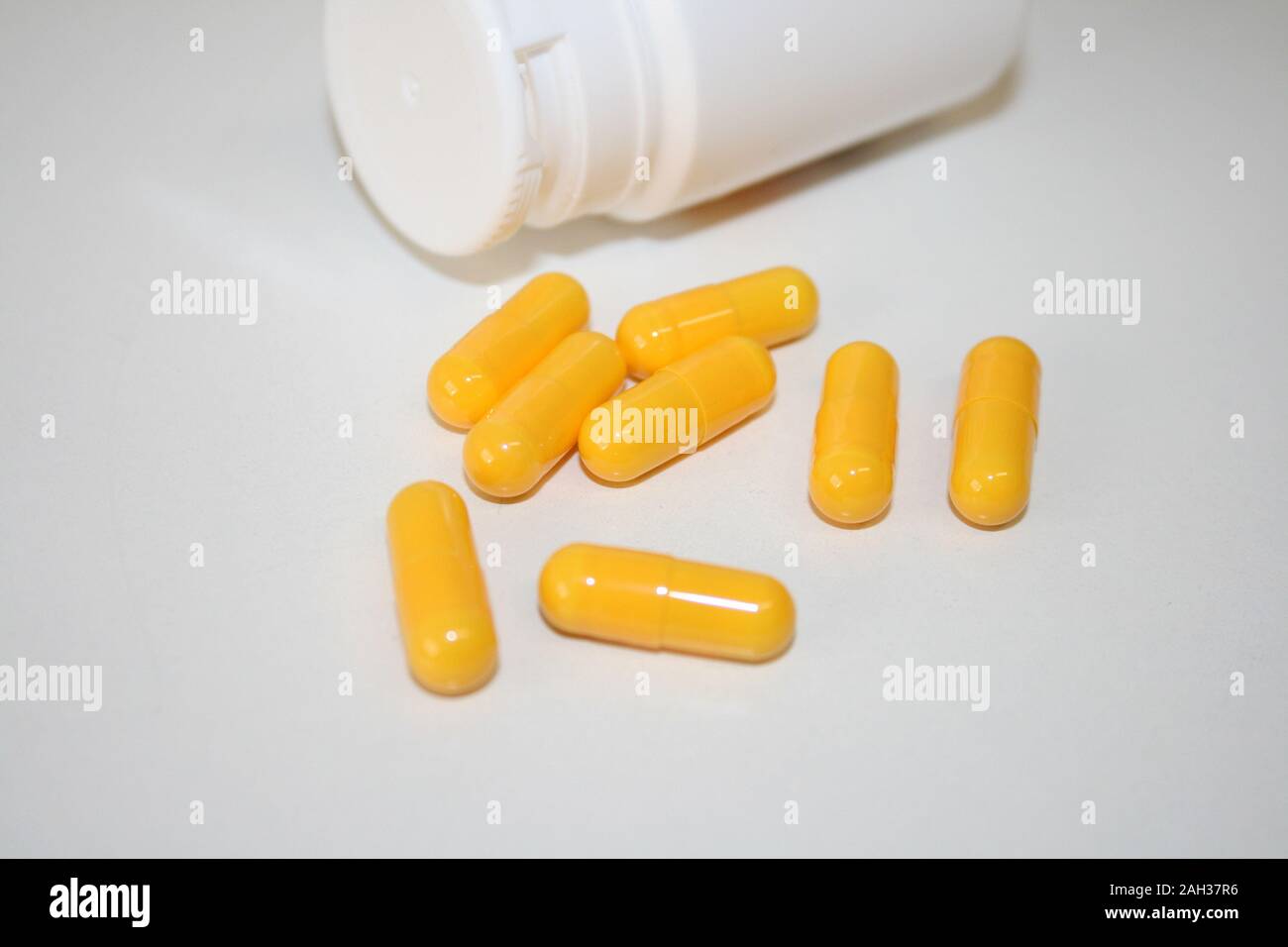 Yellow pills on a white background Stock Photo - Alamy
