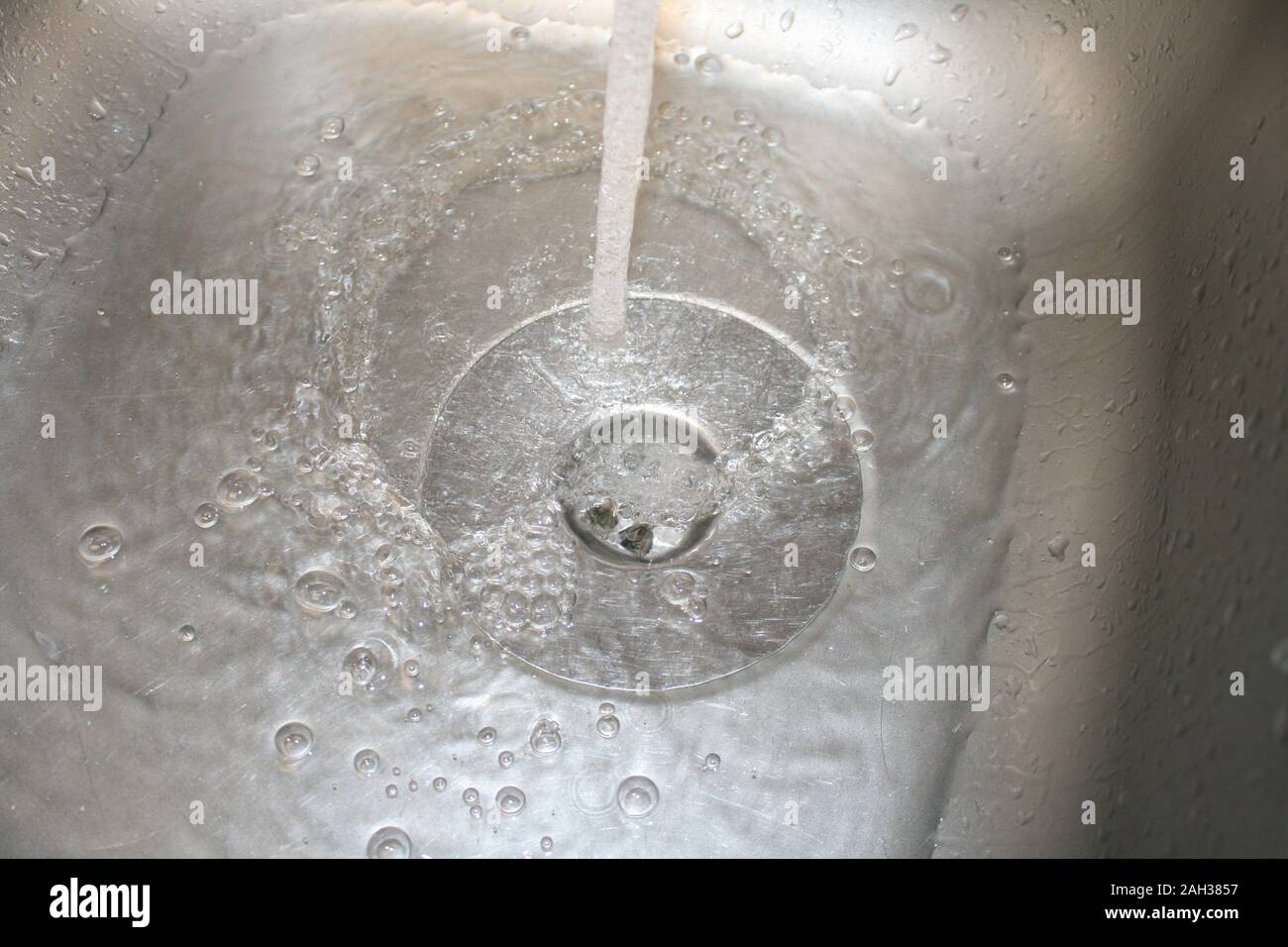 A drain from a tap with water Stock Photo - Alamy