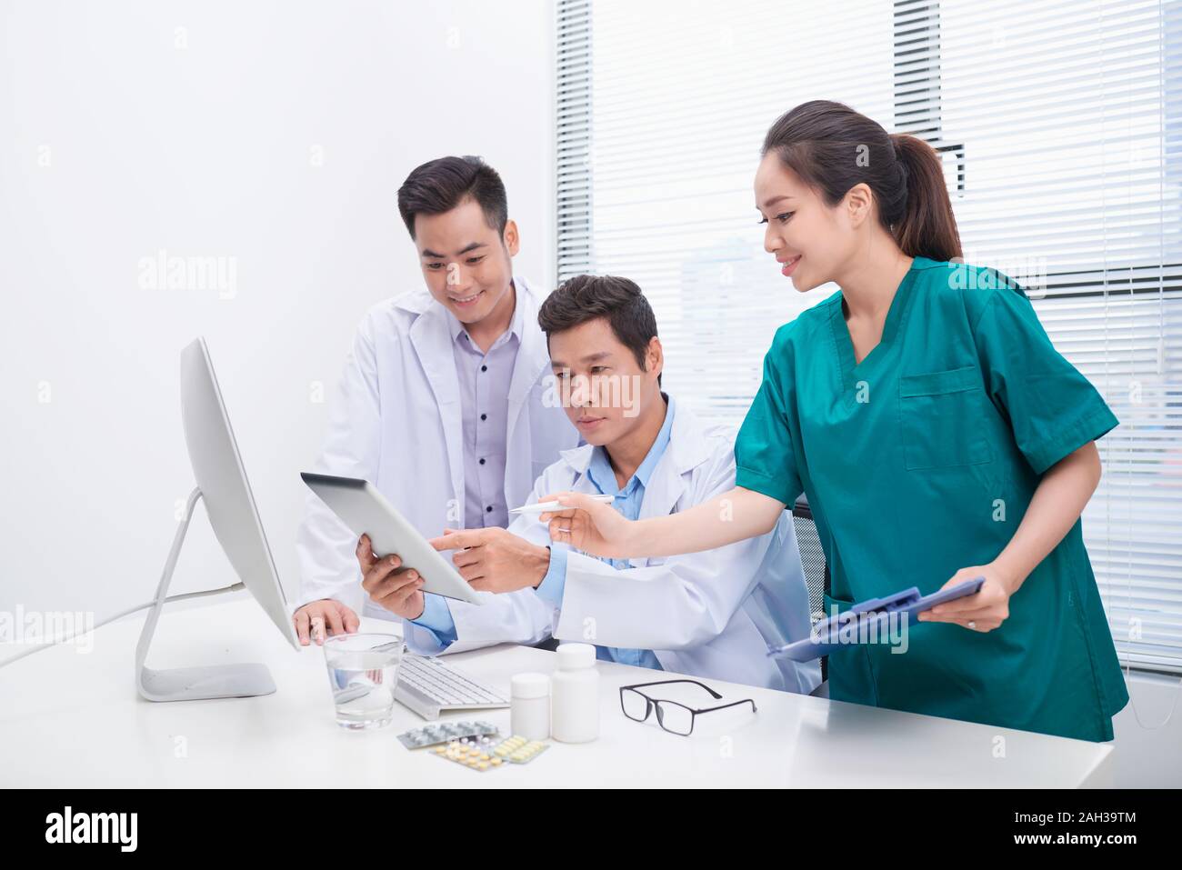 Group of doctors and nurses examining medical report of patient. Team ...