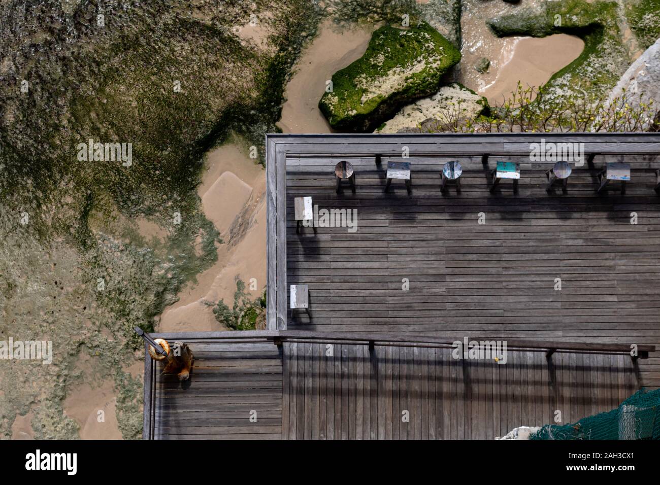Aerial view of a decked seating area on a beach with a the sea coming ...