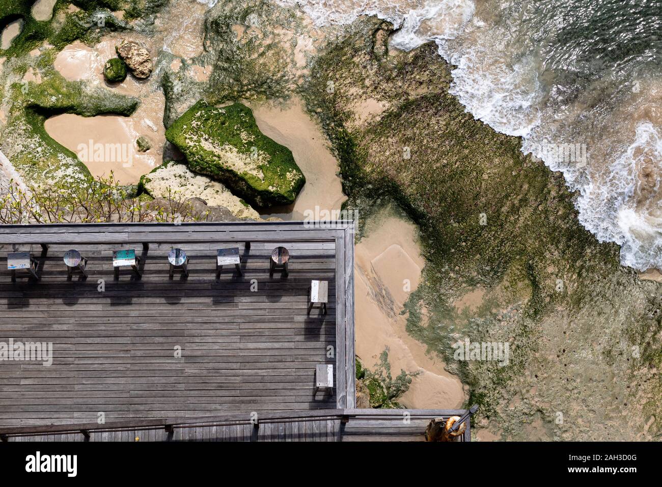 Aerial view of a decked seating area on a beach with a the sea coming ...