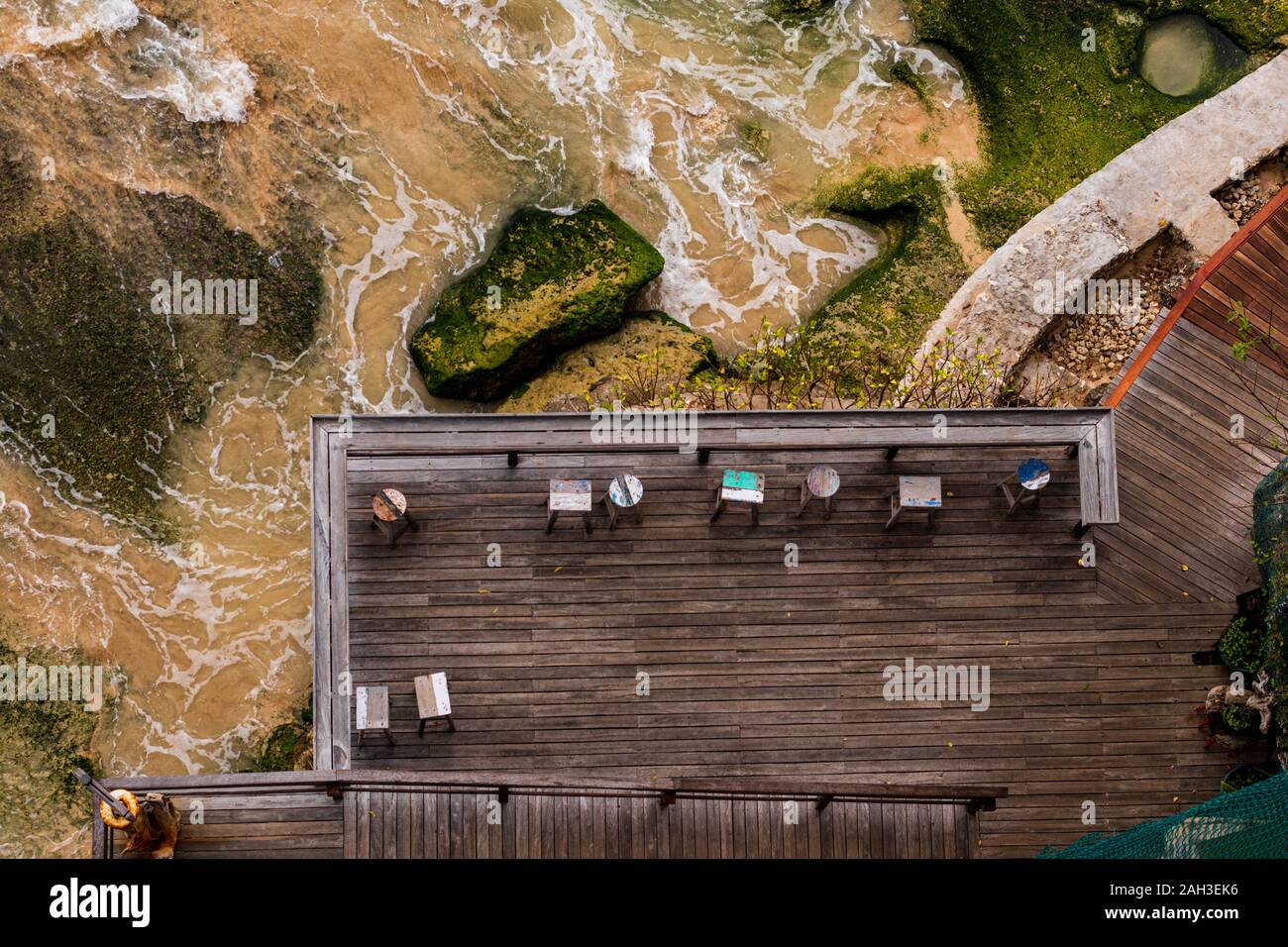 Aerial view of a decked seating area on a beach with a the sea coming ...