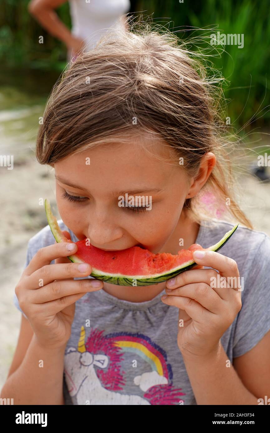 girl biting a slice of watermelon Stock Photo - Alamy