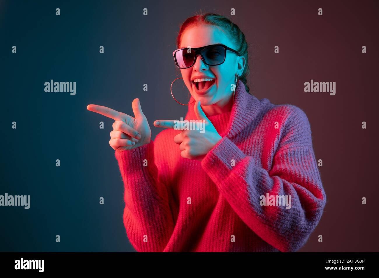 Pointing at side. Caucasian woman's portrait isolated on gradient ...