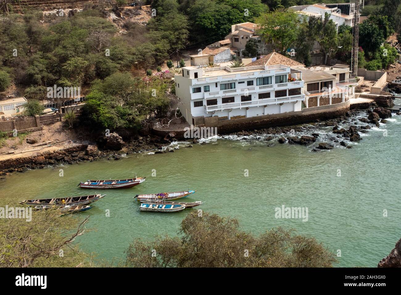 Colorful traditional fishing boats (canoes) rest at anchor in a small ...