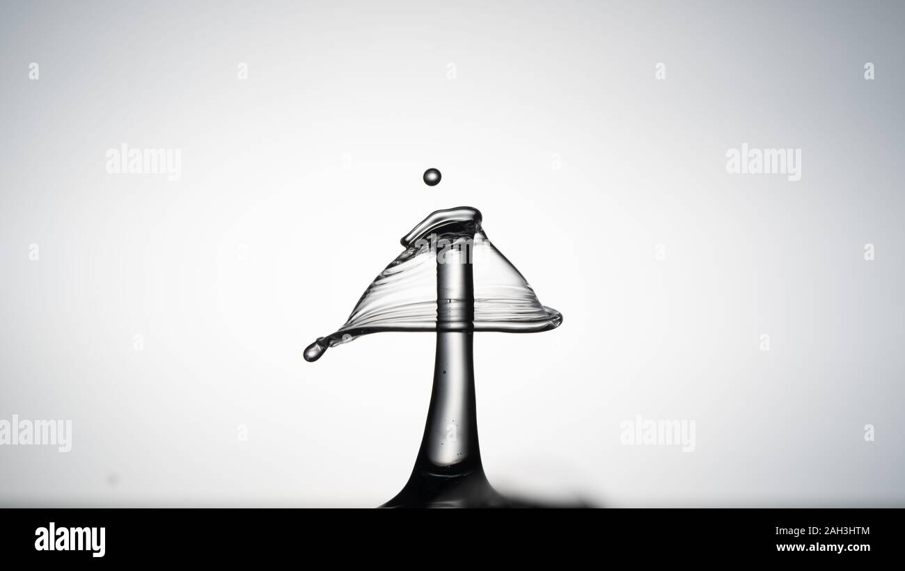 Close-up of a water drop falling on water surface Stock Photo - Alamy