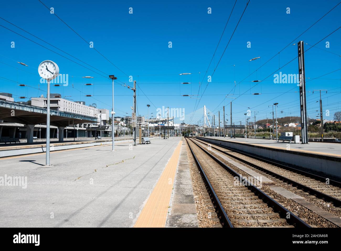 Beautiful railway station with modern commuter train at sunny day ...
