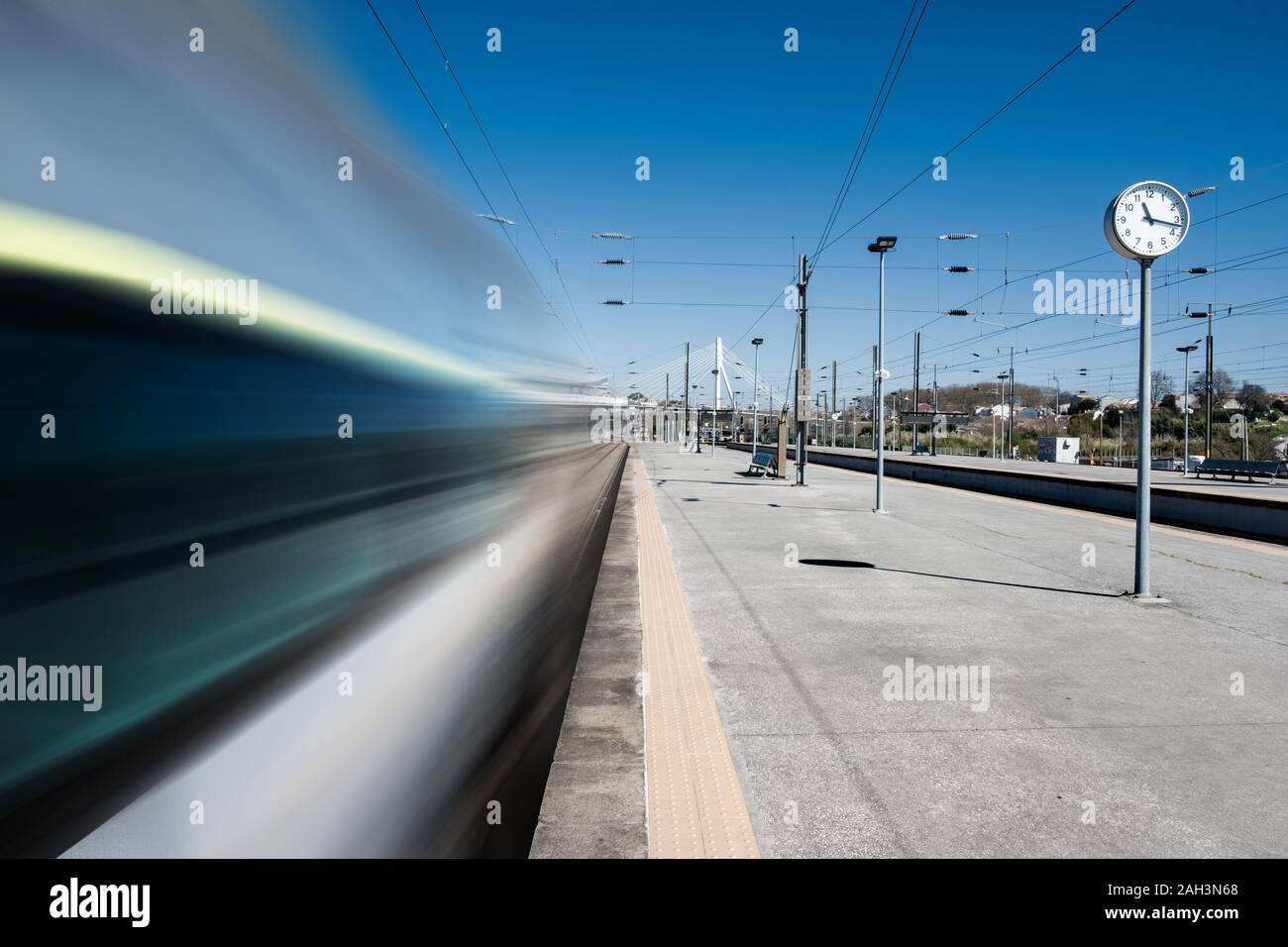 Beautiful railway station with moving modern commuter train at sunny ...