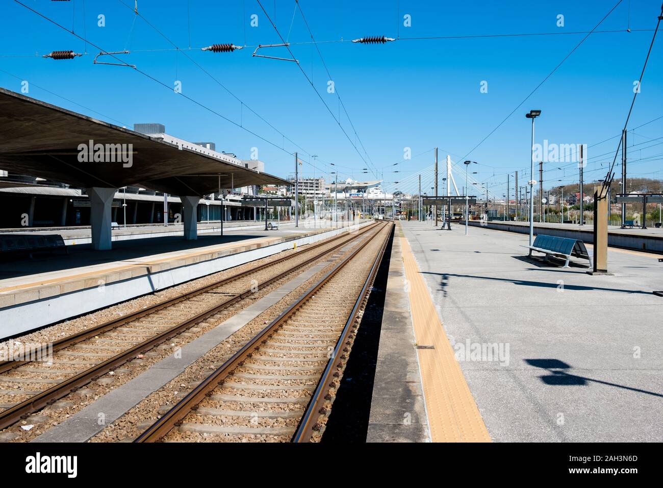 Beautiful railway station with modern commuter train at sunny day ...