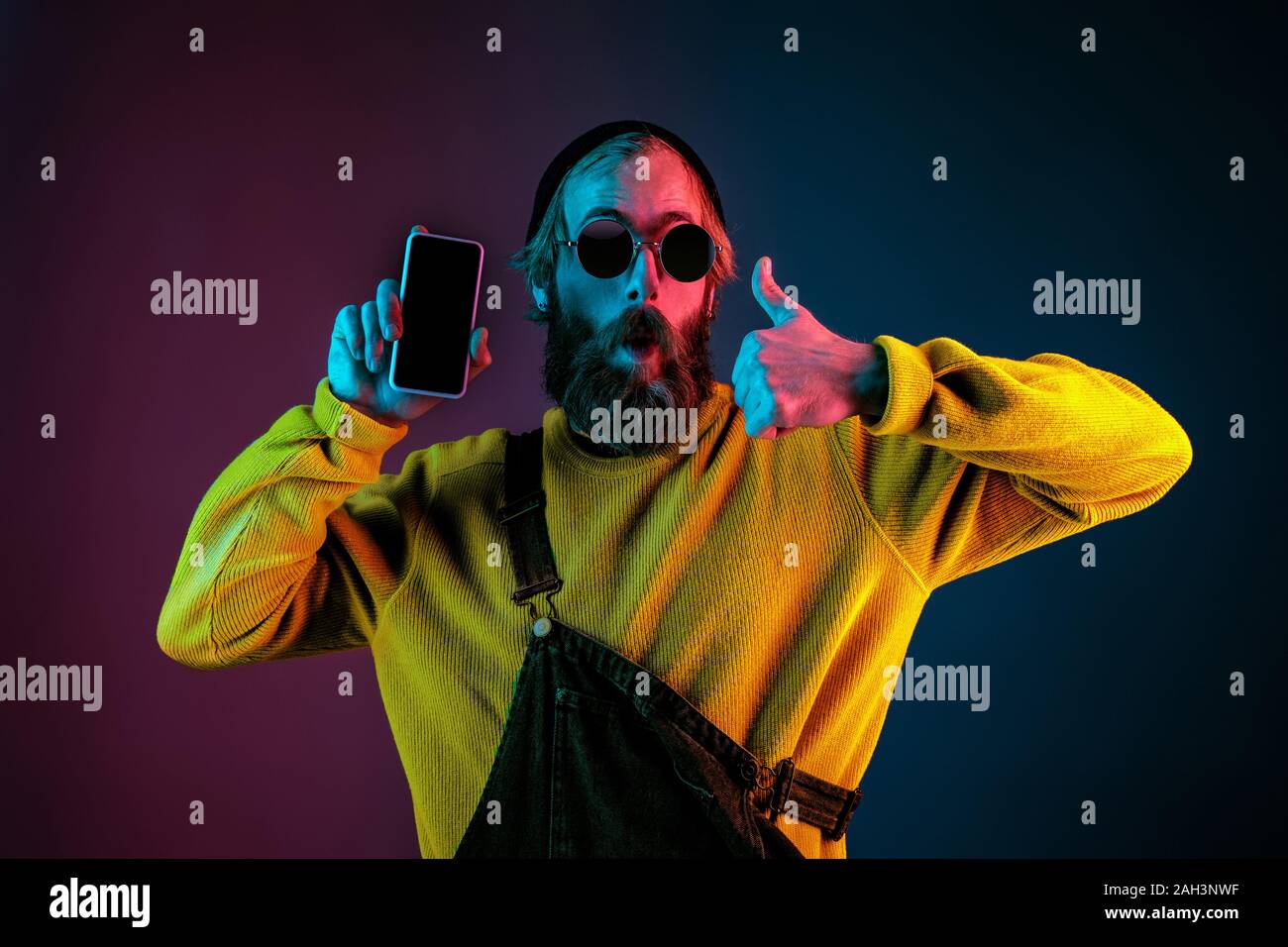 Showing phone's blank screen. Caucasian man's portrait on gradient ...