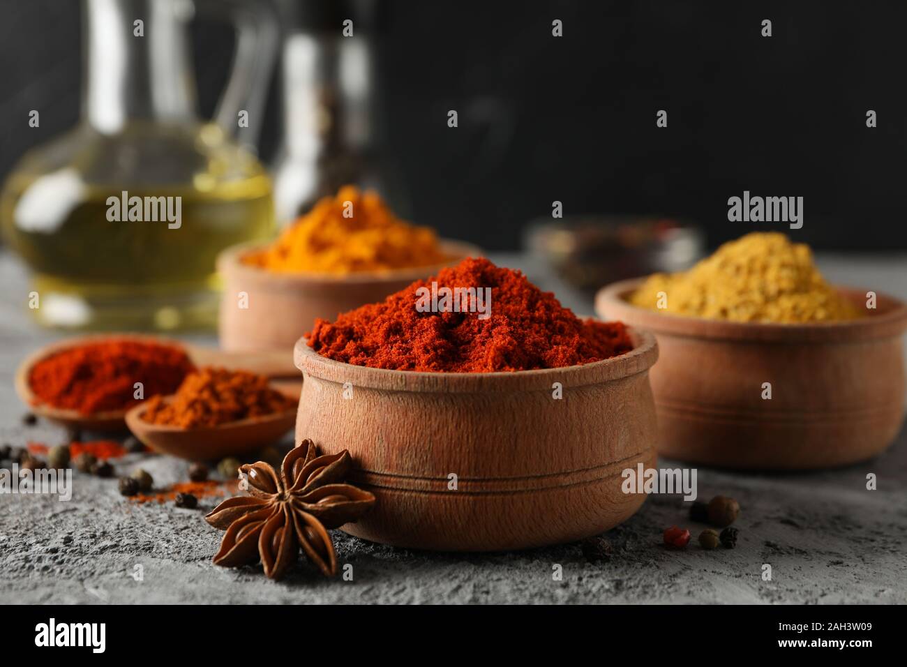 Bowls with spices and ingredients on grey background, space for text ...