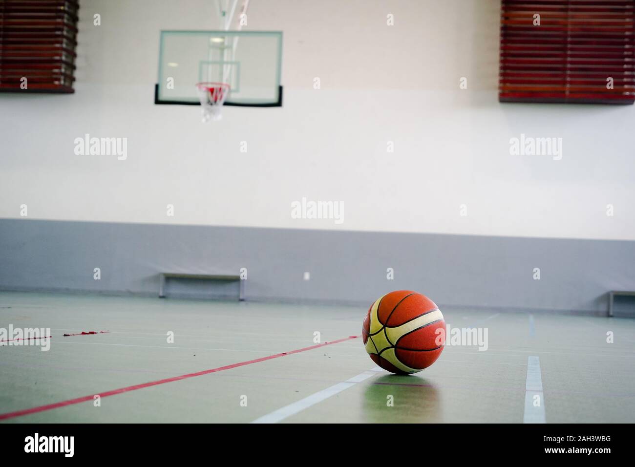 A basketball on the ground with backboard is the background. Basketball ...