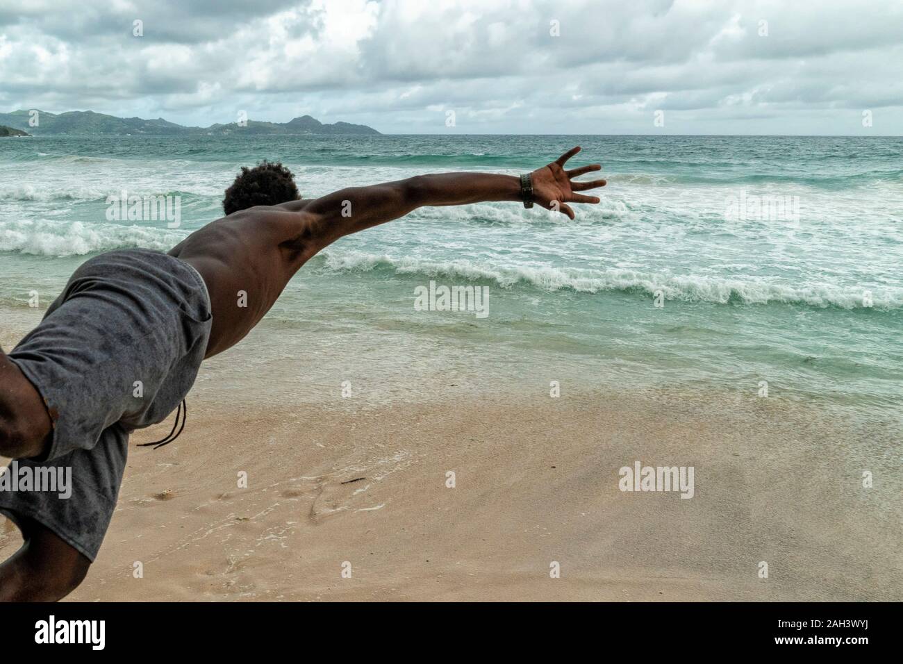Black man jumping in water in seychelles Stock Photo - Alamy