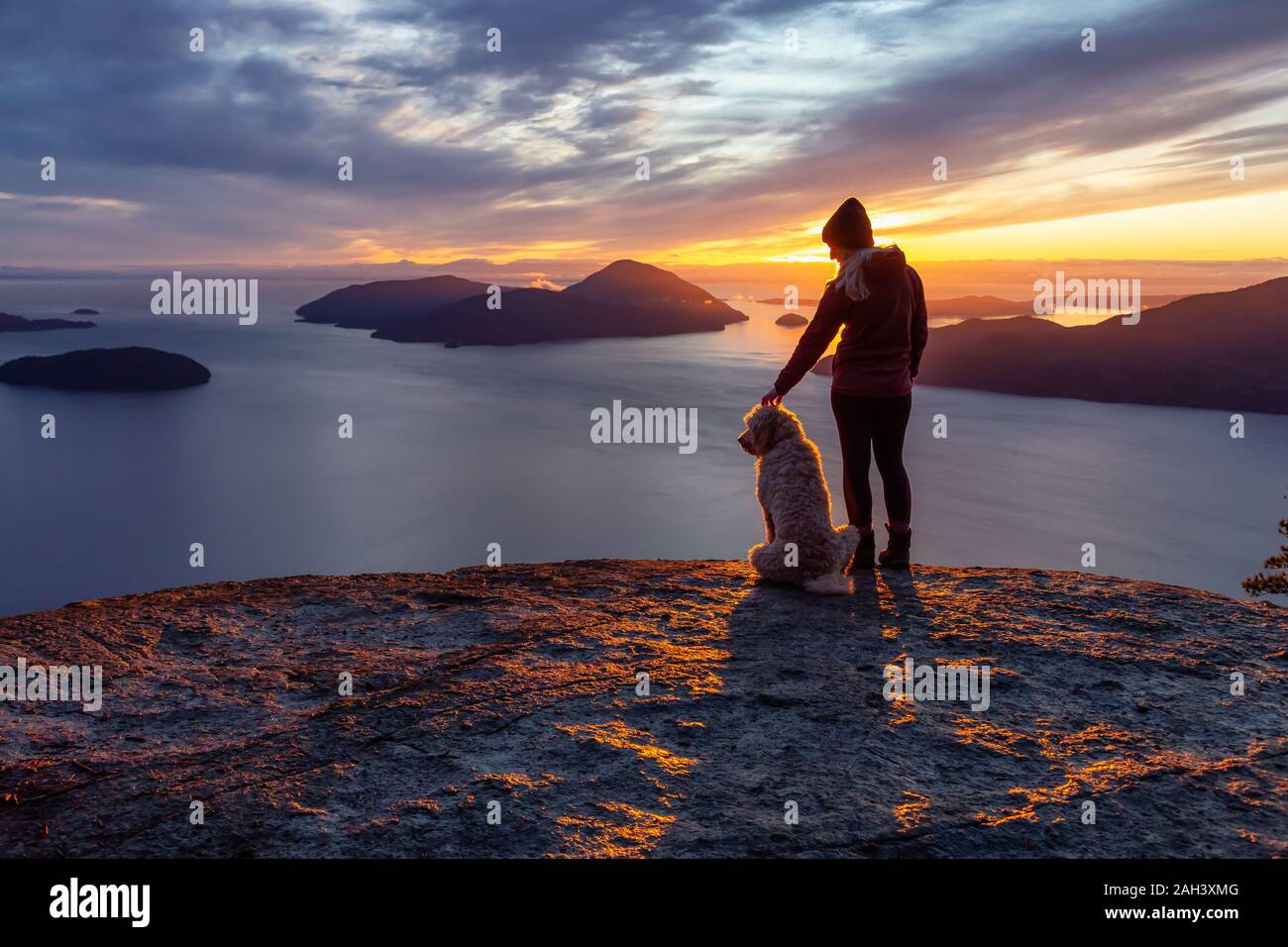 Adventurous Girl Hiking on top of a Mountain with a dog Stock Photo - Alamy