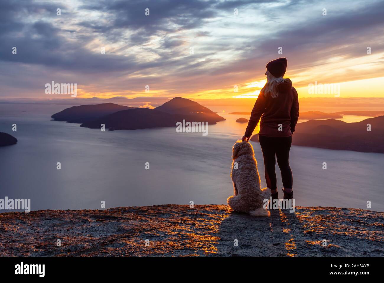 Adventurous Girl Hiking on top of a Mountain with a dog Stock Photo - Alamy