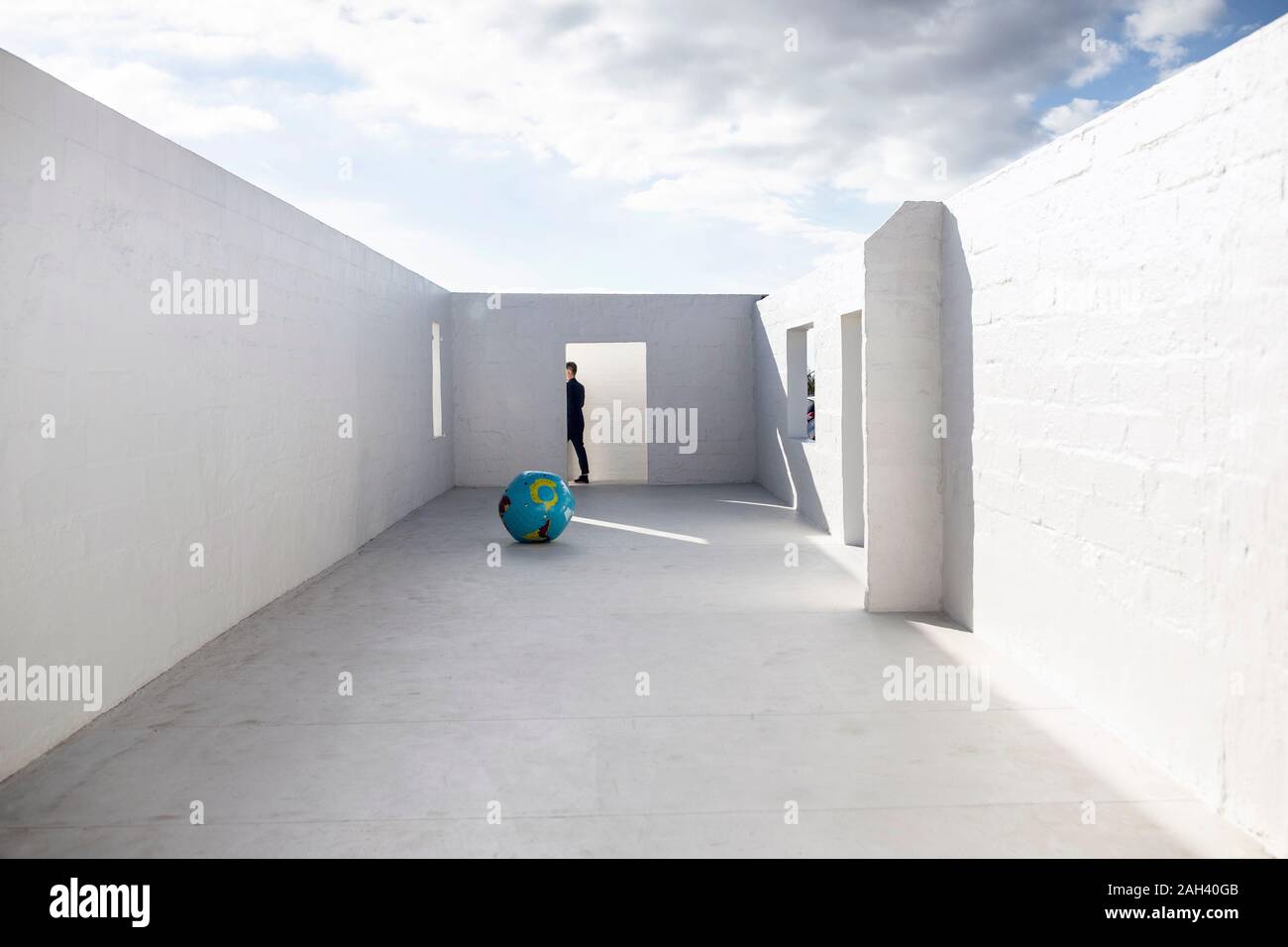 Businessman leaving room with inflatable globe Stock Photo - Alamy
