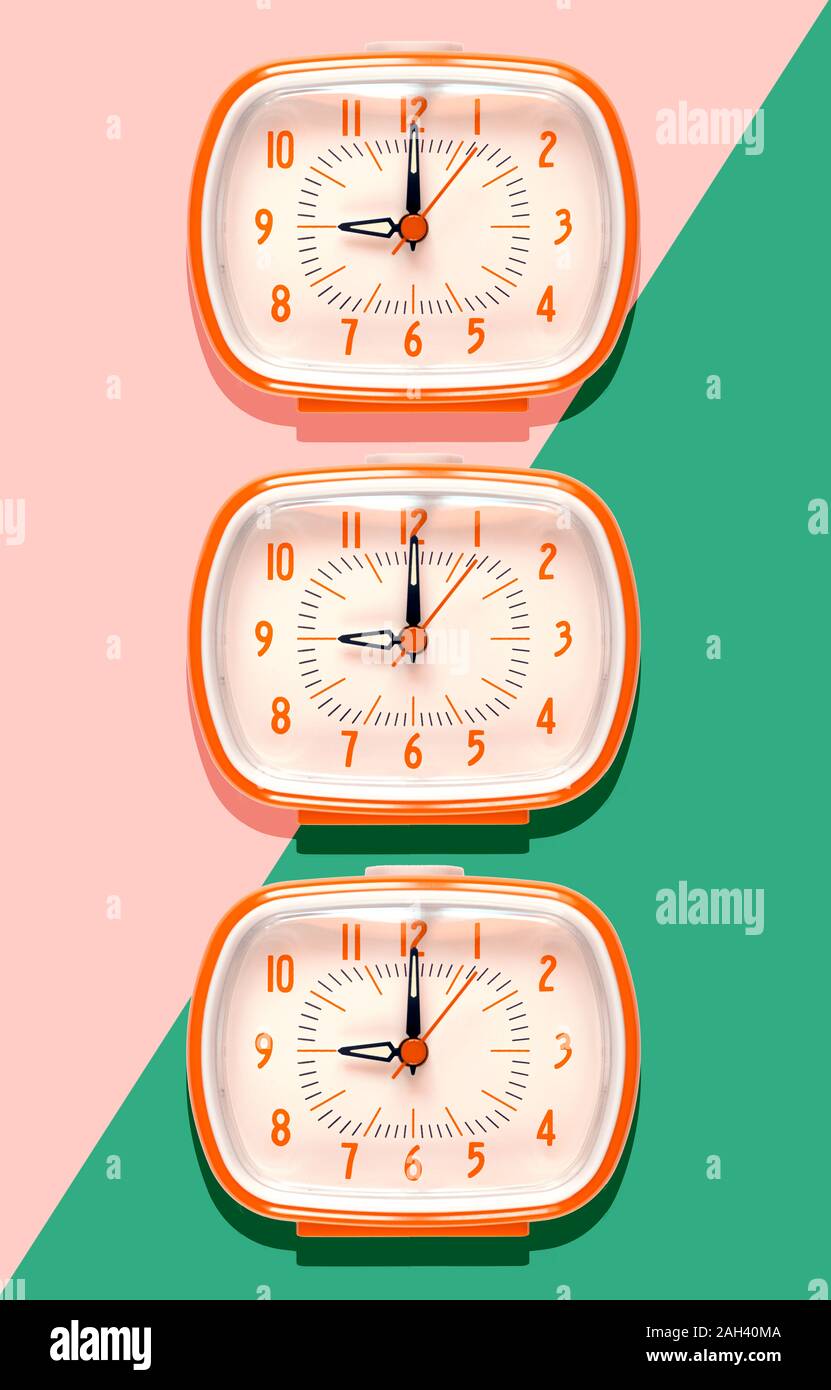 3D Illustration, row of orange alarm clocks at nine o'clock on pink and ...