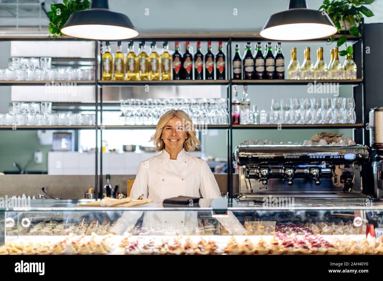 Proud bistro woner standing behind pastry counter Stock Photo - Alamy