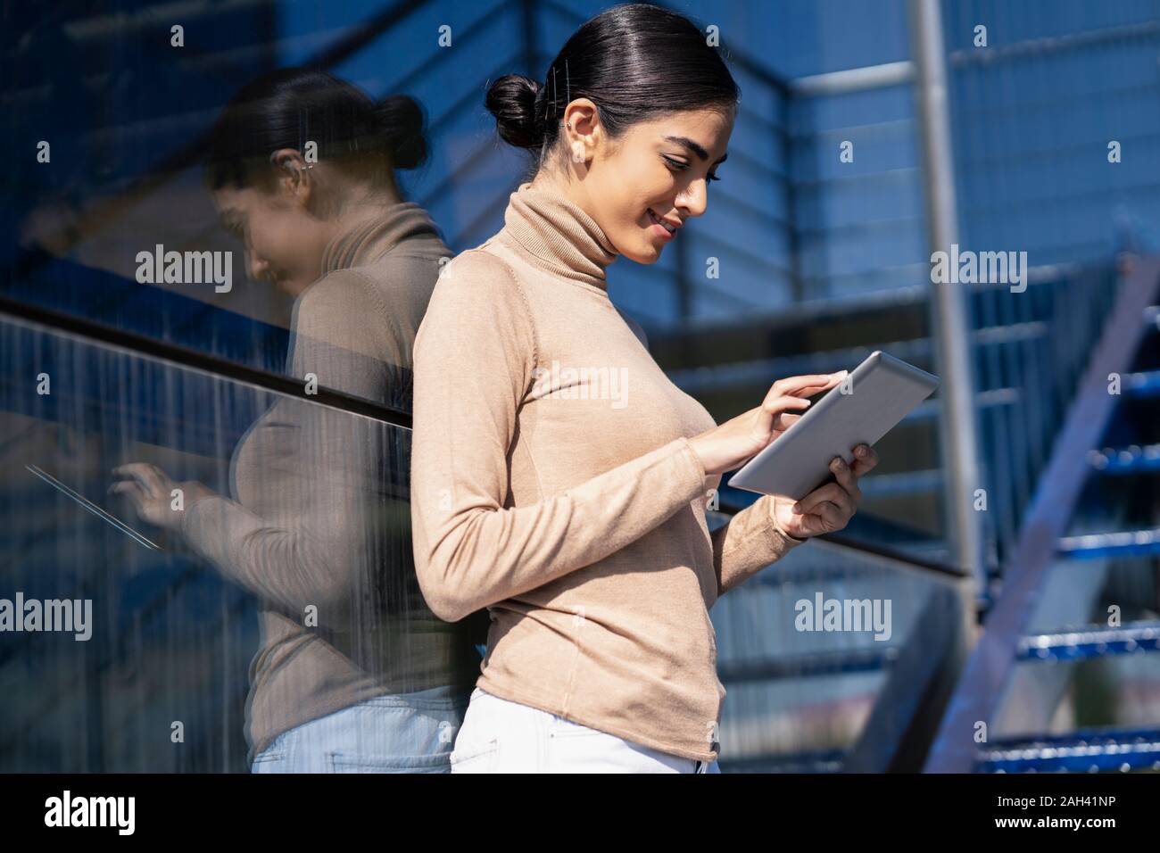 Young woman using tablet on exterior stairs Stock Photo - Alamy