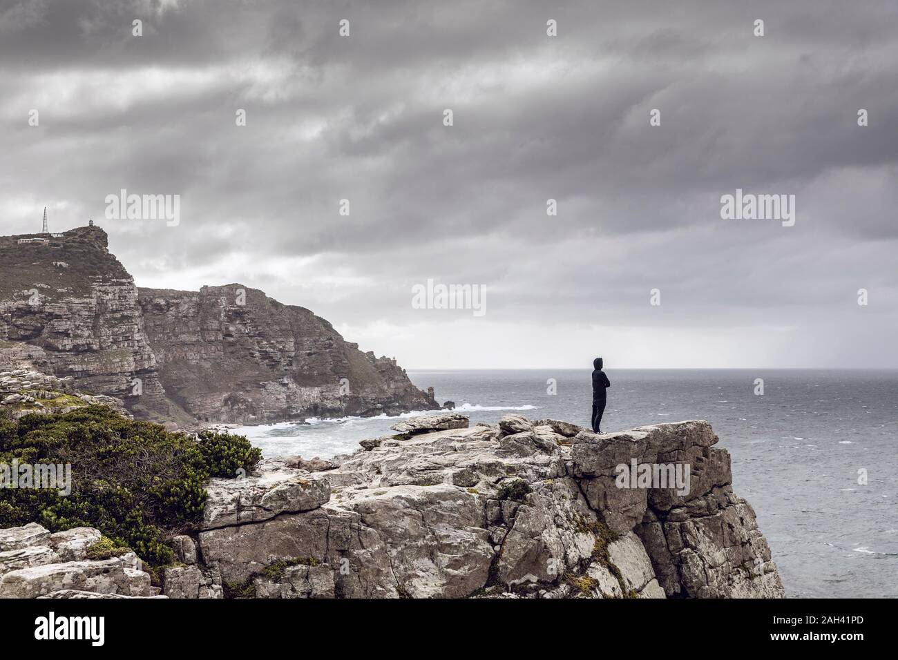 Man standing on rocky cliff looking at horizon, Cape Point, Western ...