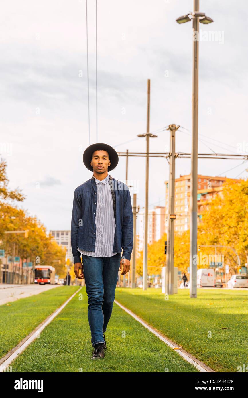 Fashionable young man walking on tram rails Stock Photo - Alamy