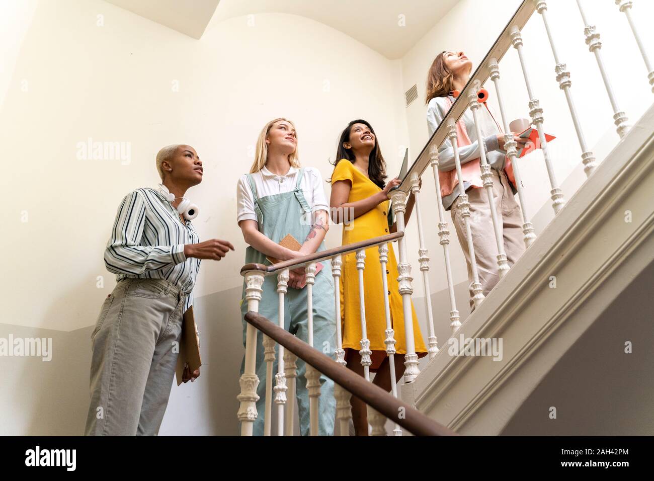 Four confident women walking upstairs in staircase Stock Photo - Alamy