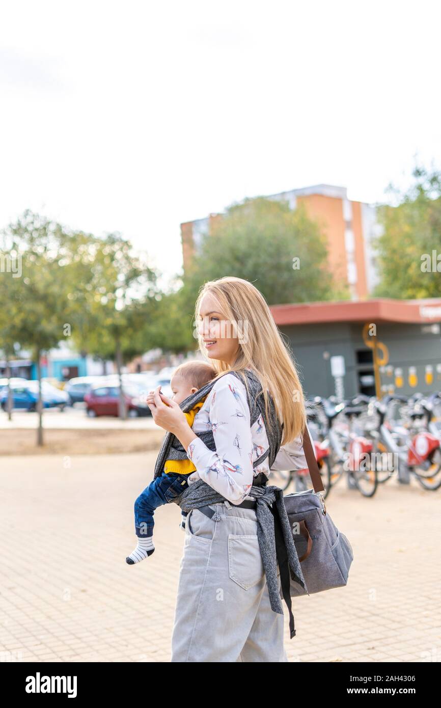 Women carrying her baby in a baby carrier hi-res stock photography and ...