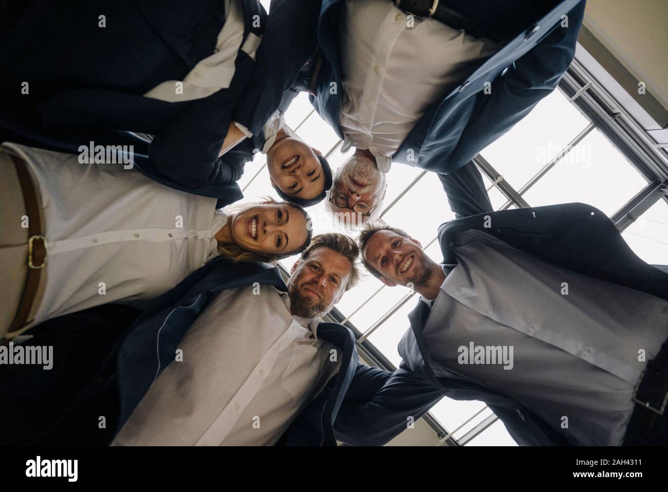 Happy business people huddling in office Stock Photo - Alamy
