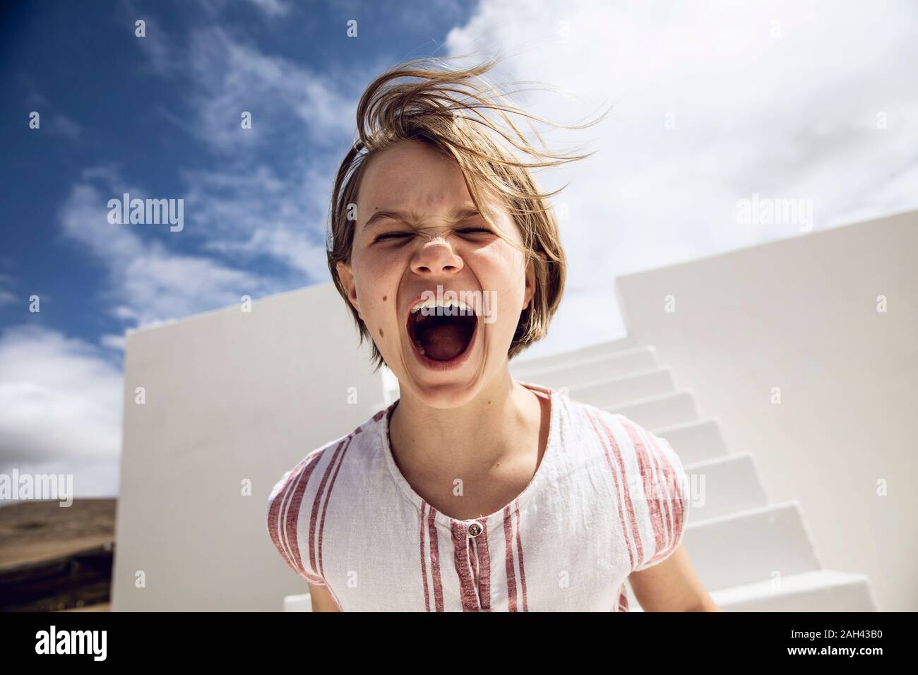 Girl with windswept hair, screaming out loud Stock Photo - Alamy