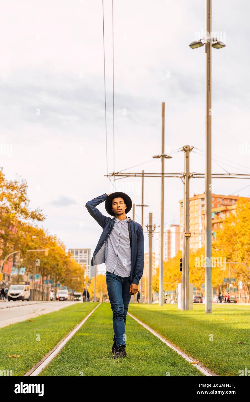 Fashionable young man walking on tram rails Stock Photo - Alamy