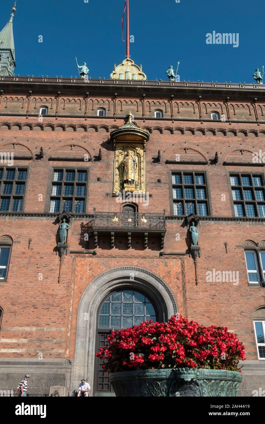 A standing golden statue on the facade of the City Hall building ...