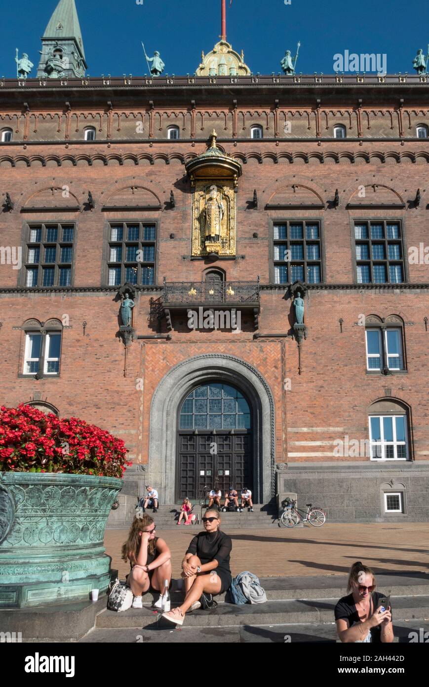 A standing golden statue on the facade of the City Hall building ...