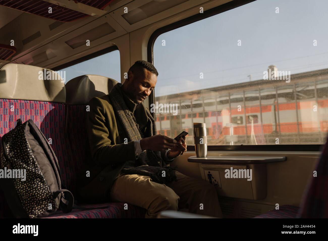 Stylish man using smartphone inside a train Stock Photo - Alamy