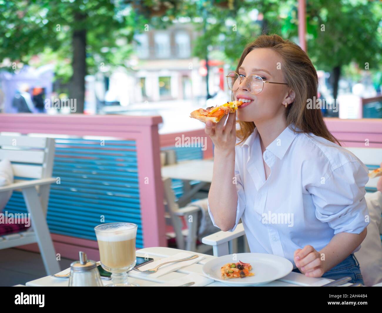 Happy woman eating pizza in summer cafe Stock Photo - Alamy