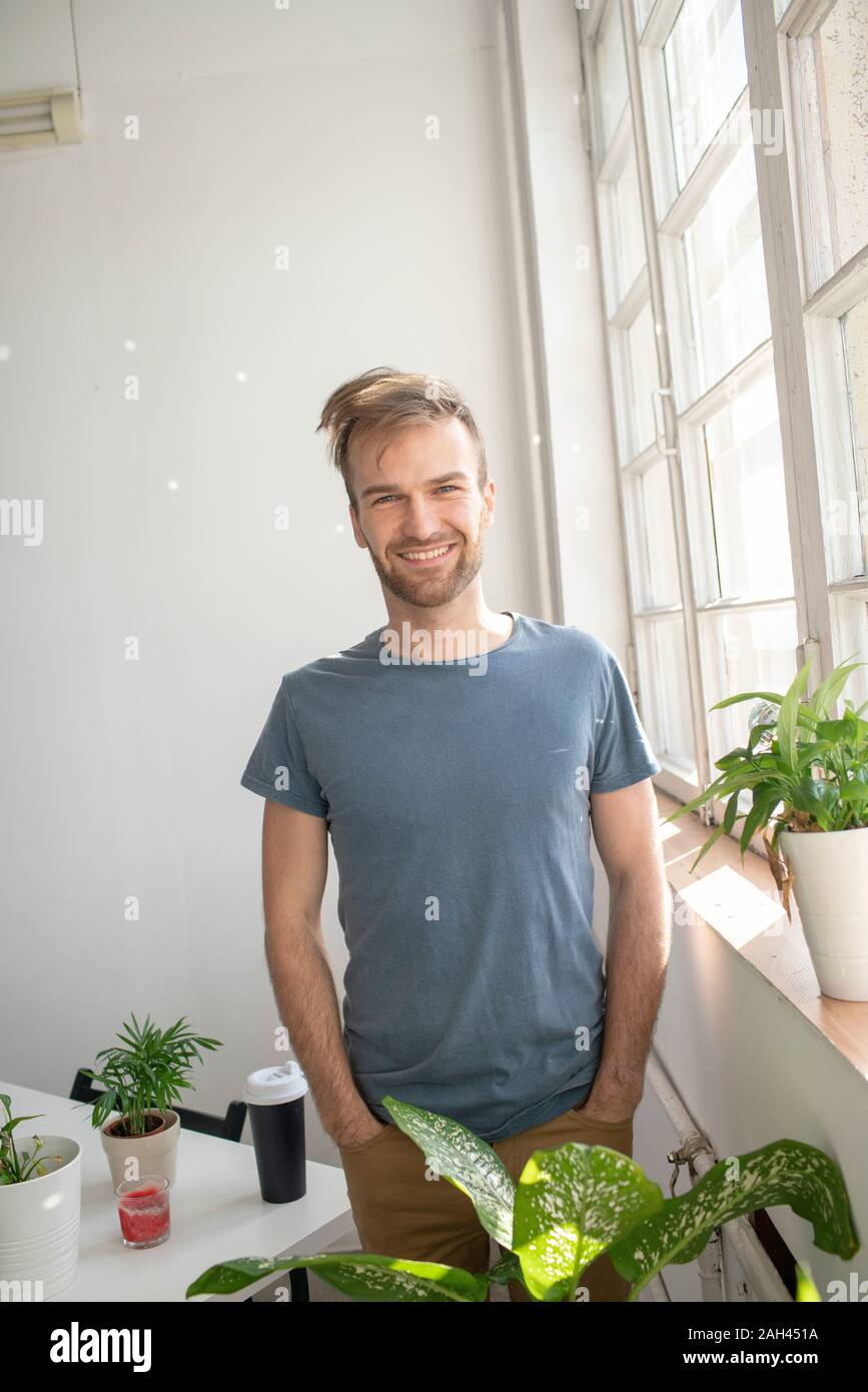 Portrait of smiling man standing at the window in office Stock Photo ...