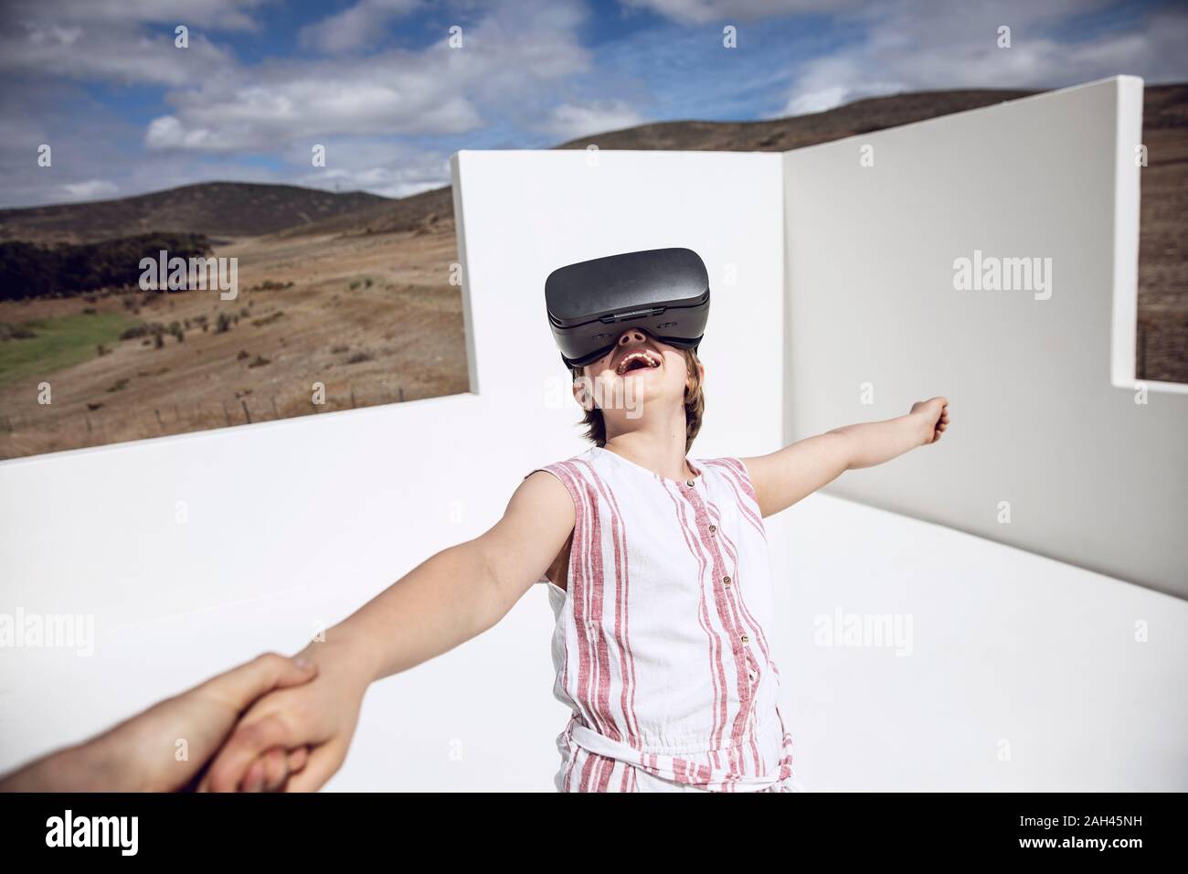 Girl looking through VR goggles in open space Stock Photo - Alamy