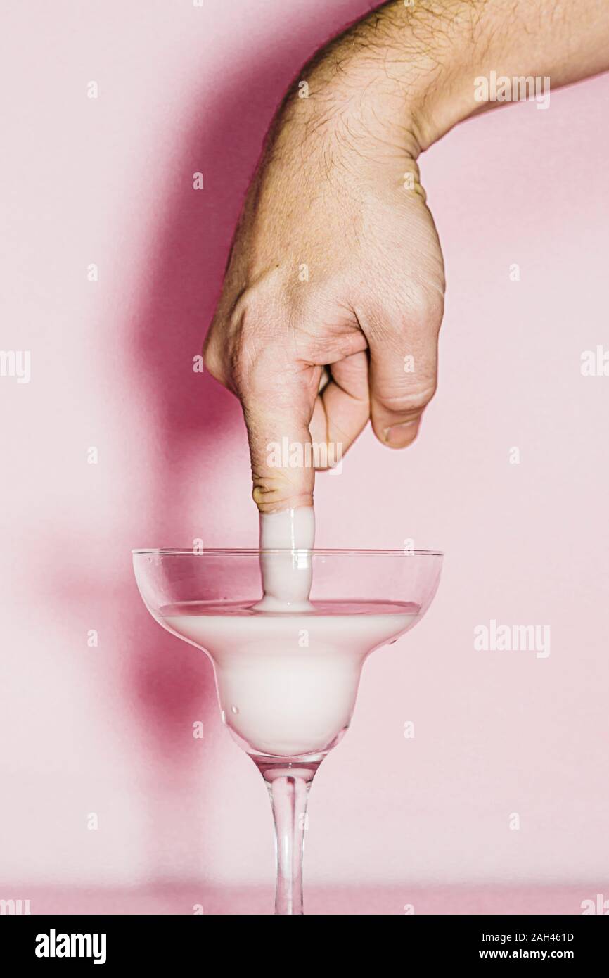 Man dipping his finger into a liquid in a glass Stock Photo - Alamy