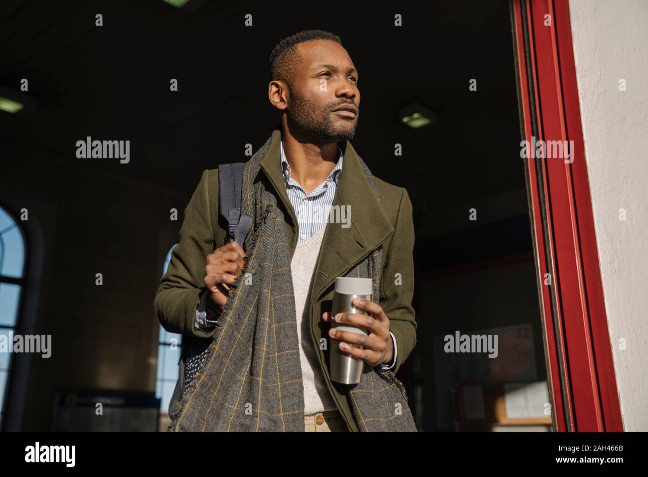 Stylish man with reusable cup getting out of the train station Stock ...