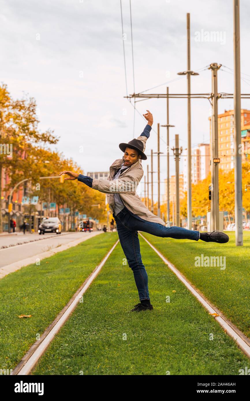 Young man moving and dancing on tram rails Stock Photo - Alamy