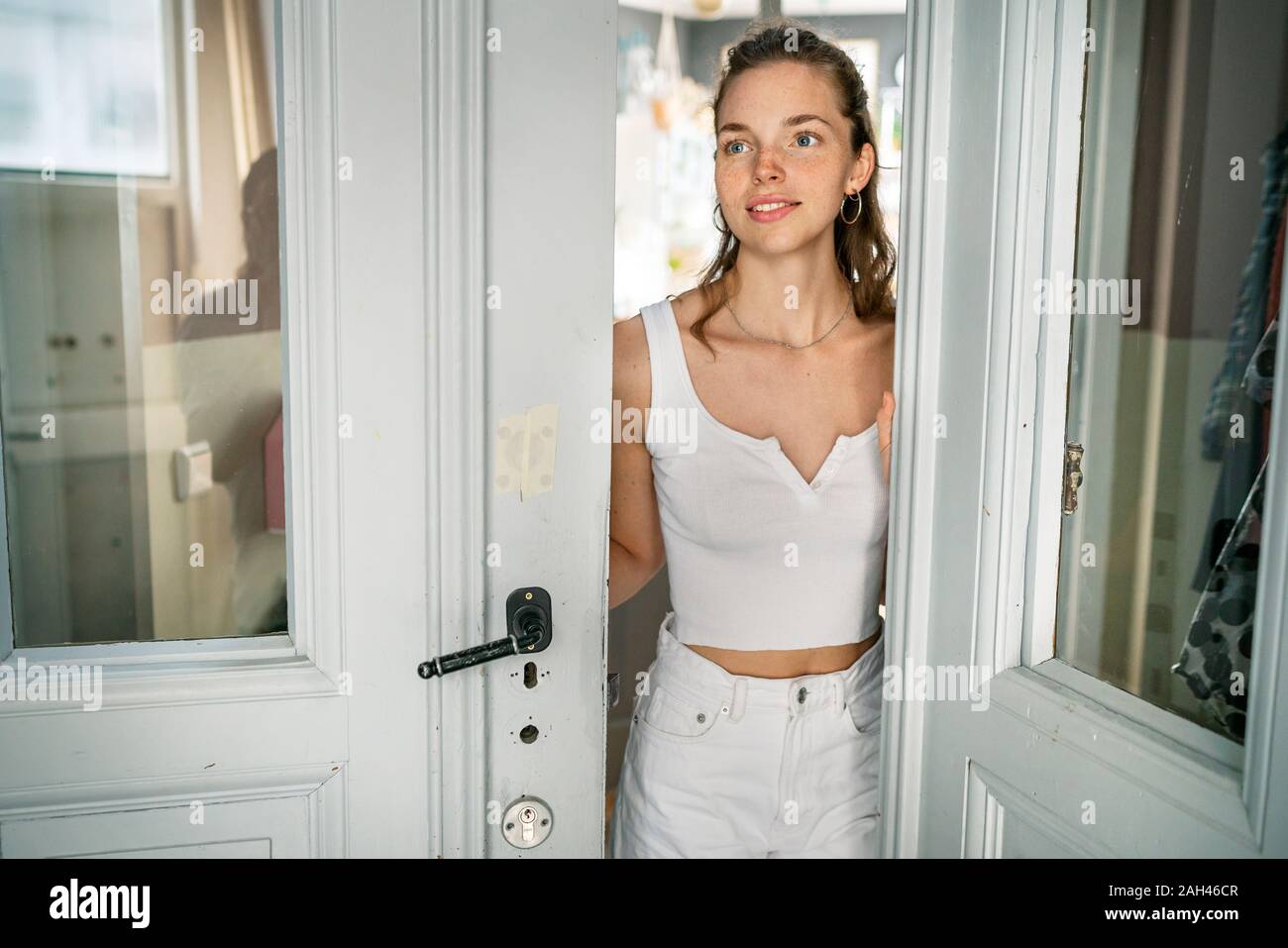 Woman opening front door hi-res stock photography and images - Alamy