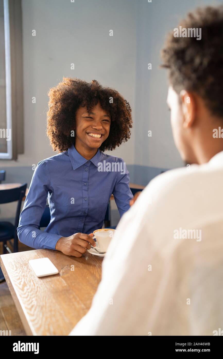 Students drinking coffee in a cafe, woman laughing Stock Photo - Alamy