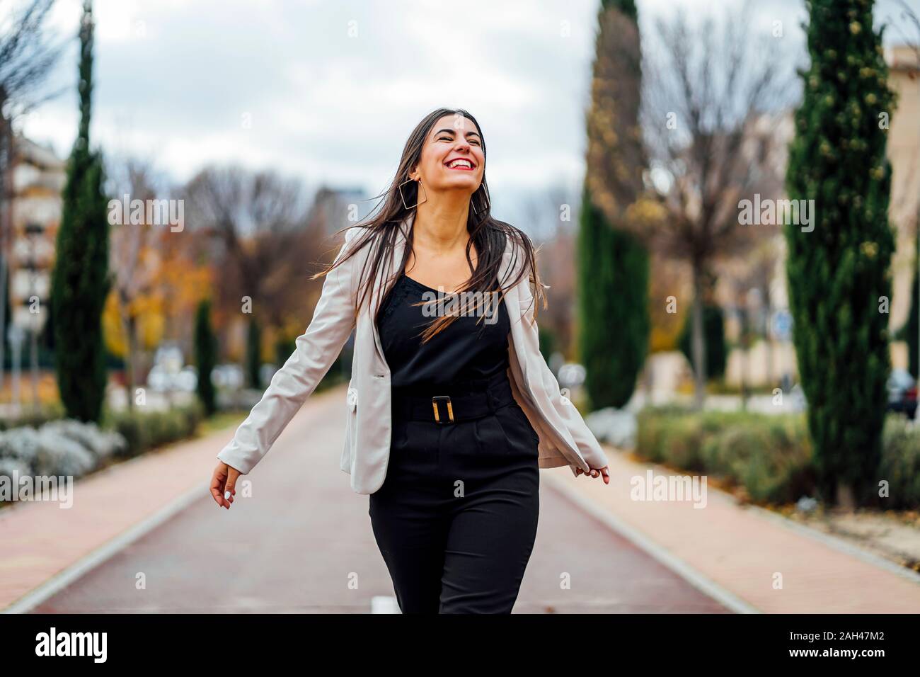 Smiling businesswoman walking and laughing Stock Photo - Alamy