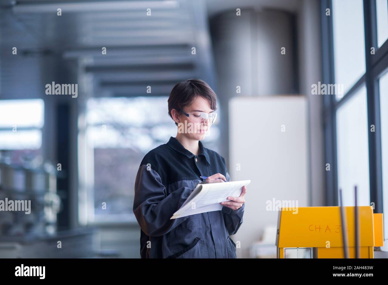 Female technician at work taking notes Stock Photo - Alamy